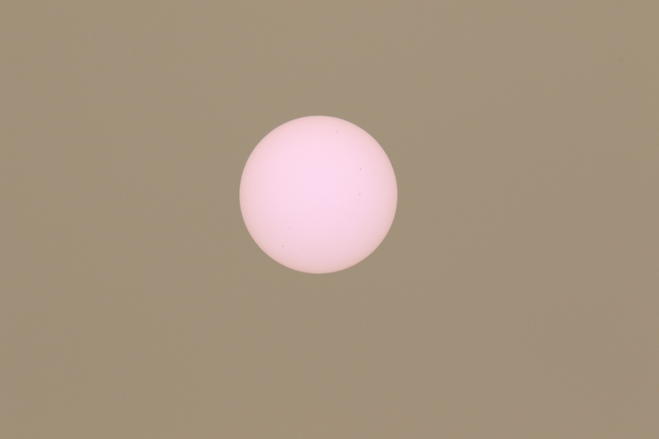Pale, pink sun seen in New Brunswick due to wild fire smoke high in the ...